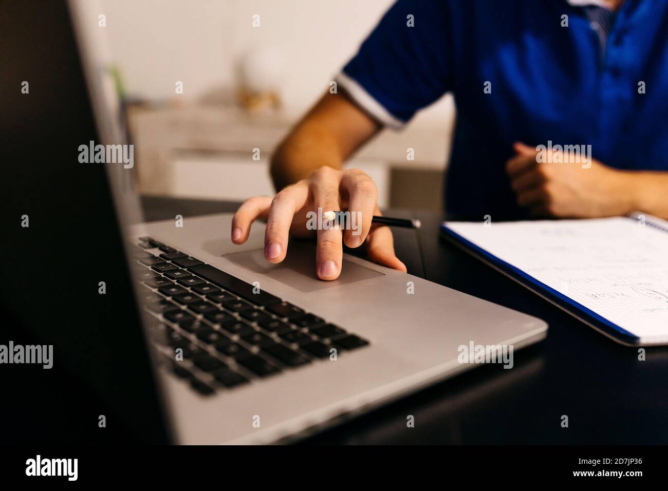 Adult male student using laptop while doing homework at table Stock ...