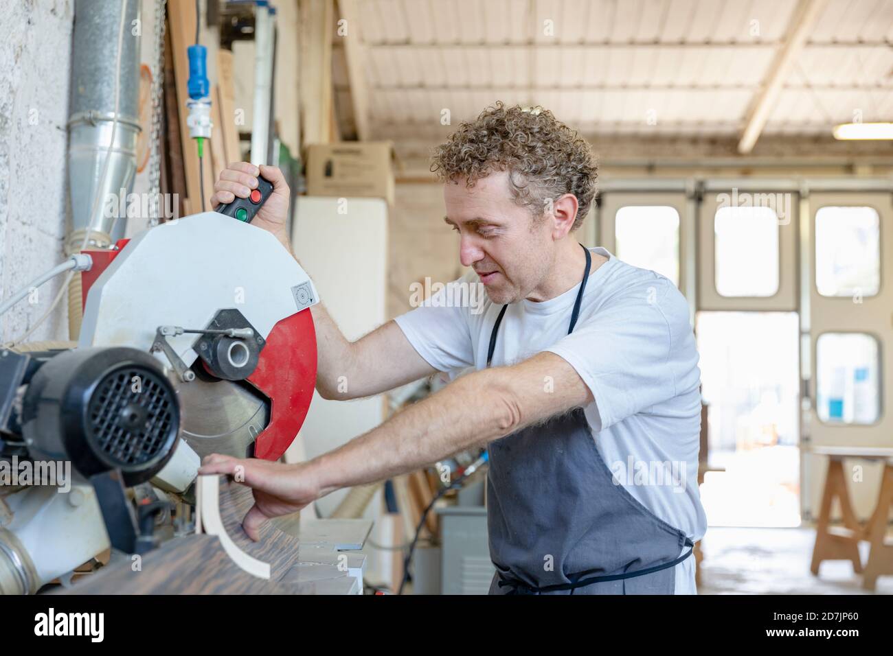 Man operating electric saw machine while standing at workshop Stock ...