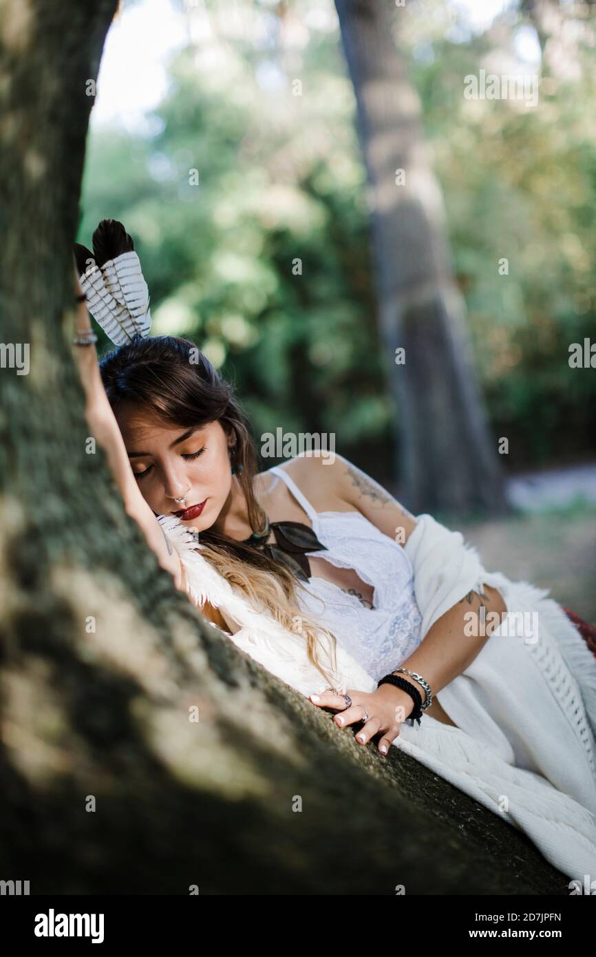 Beautiful woman resting under tree at park Stock Photo - Alamy