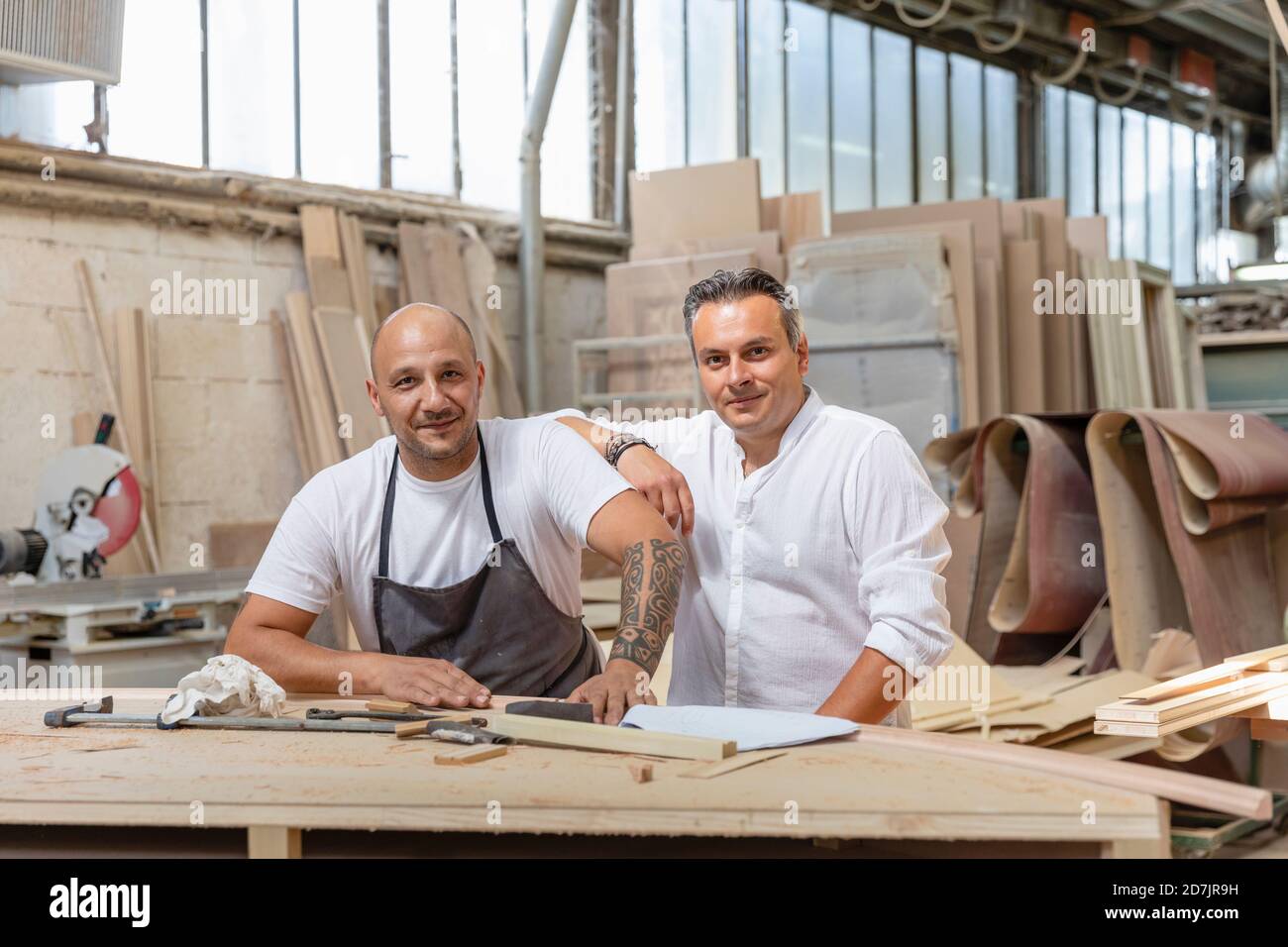 Smiling project manager and coworker standing in factory Stock Photo ...