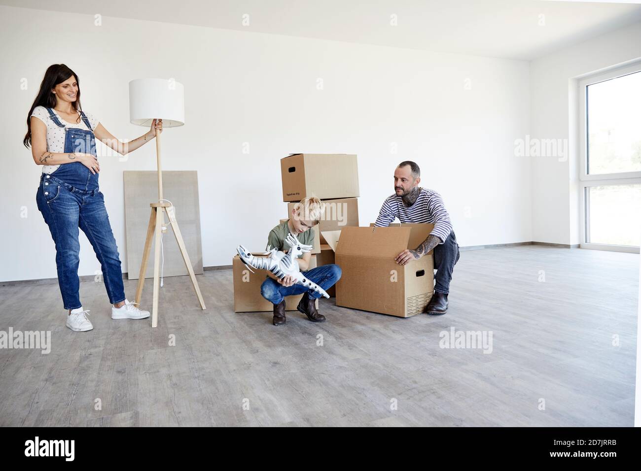 Pregnant mother holding electric lamp while father and son crouching on ...
