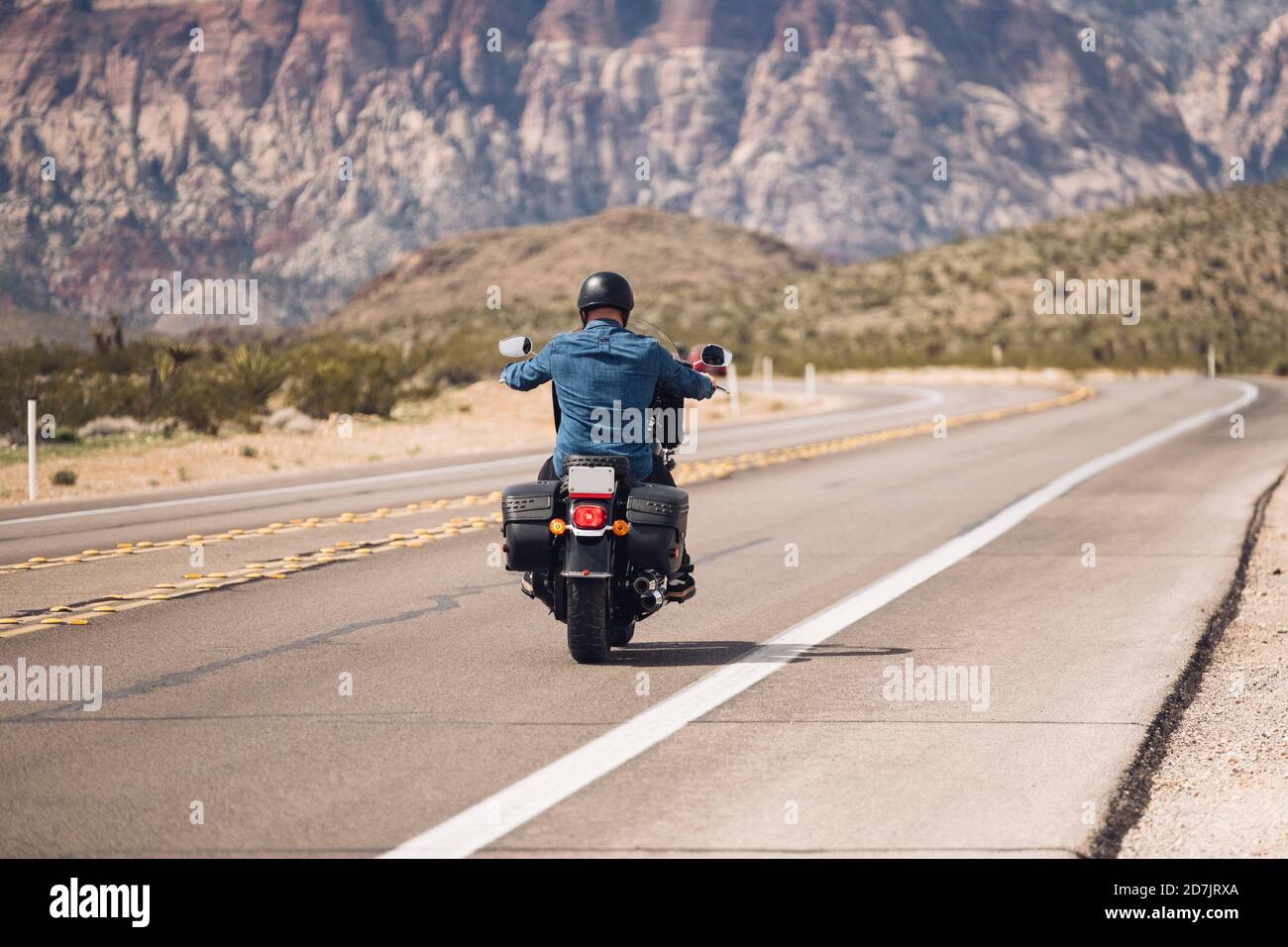 Man riding motorcycle on desert road, Nevada, USA Stock Photo - Alamy