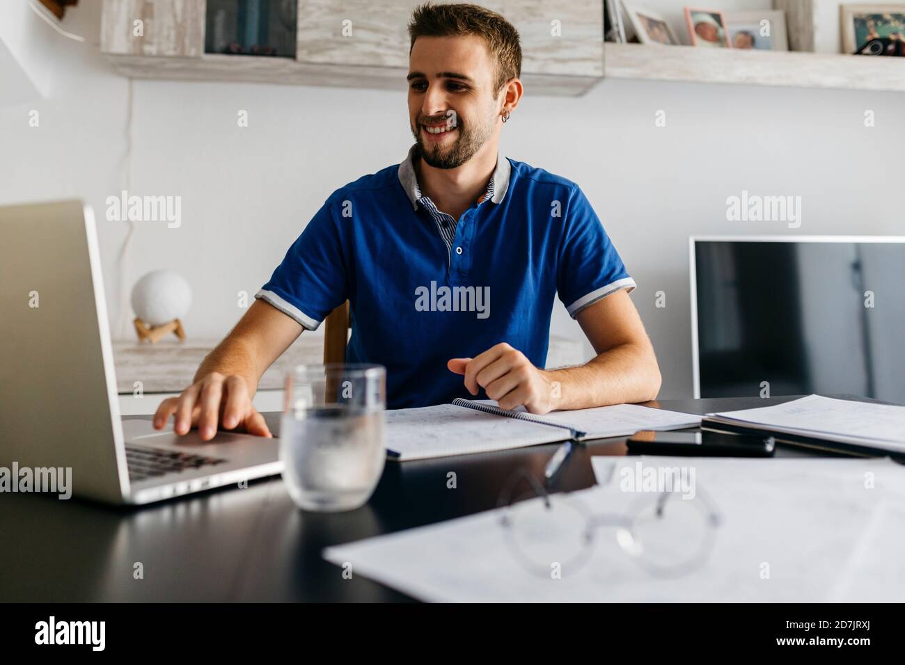 Handsome smiling man using laptop in his bed in bright bedroom Stock ...