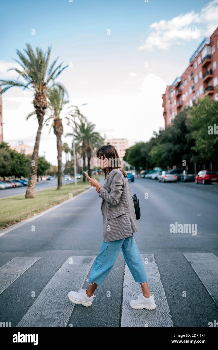 Young woman walking zebra crossing hi-res stock photography and images ...