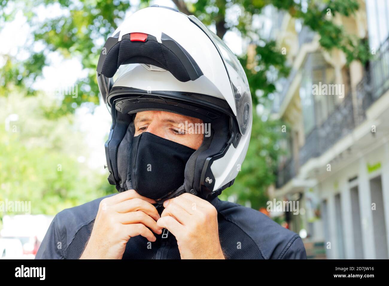Male biker putting on helmet Stock Photo - Alamy