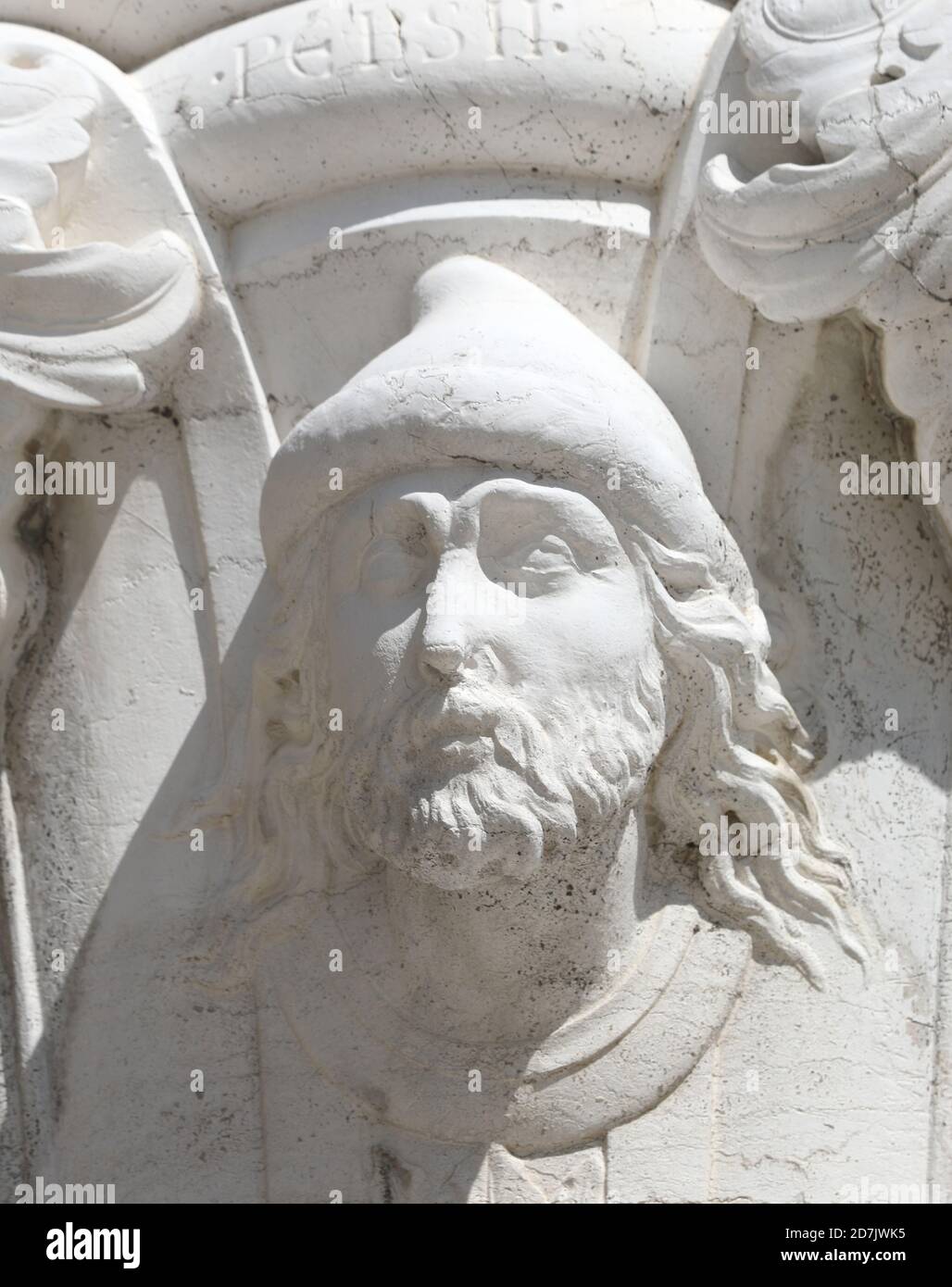 white face of man with beard and long hair carved on the stone of the ...