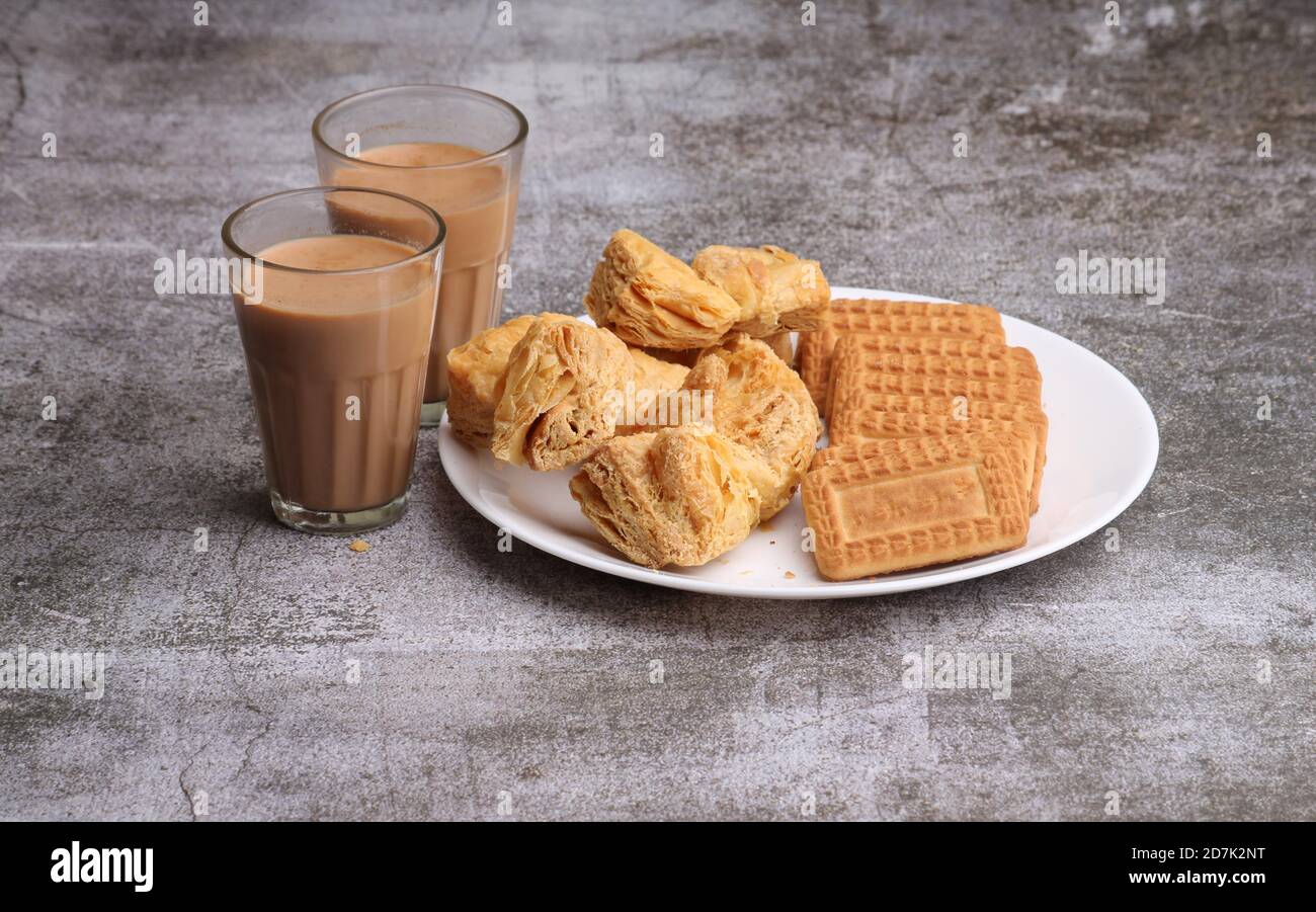 cutting masala chai or tea served with puff pastry/ khari and biscuits ...
