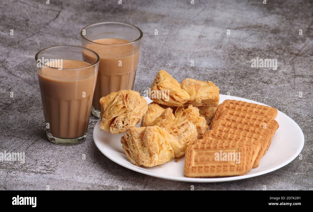 cutting masala chai or tea served with puff pastry/ khari and biscuits ...
