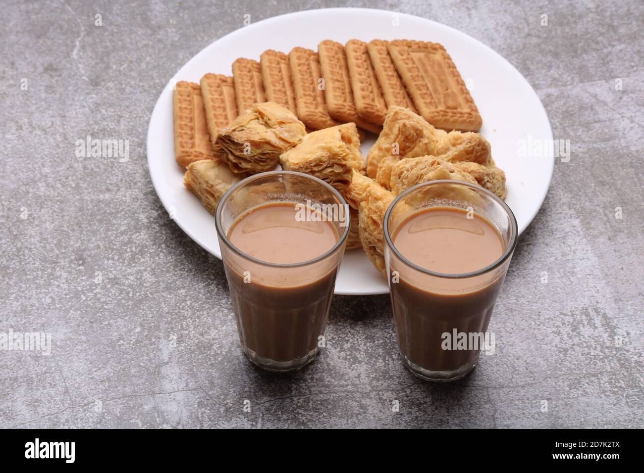 cutting masala chai or tea served with puff pastry/ khari and biscuits ...