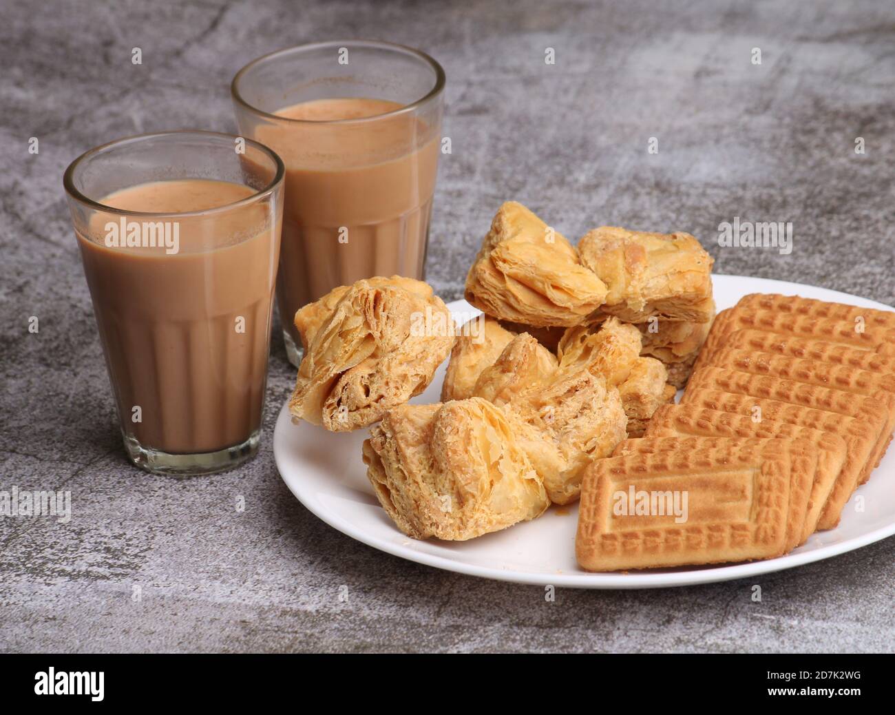 cutting masala chai or tea served with puff pastry/ khari and biscuits ...