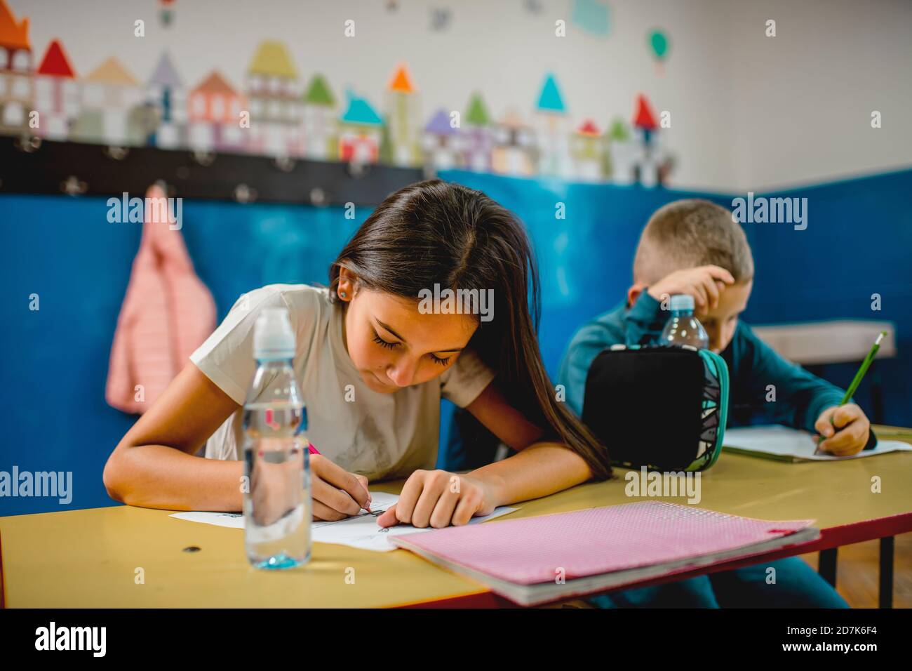 Elementary schoolchildren writing at the desk in the classroom Stock ...