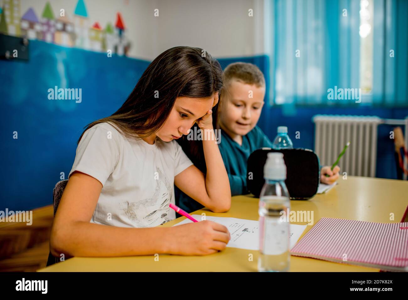 Elementary schoolchildren writing at the desk in the classroom Stock ...