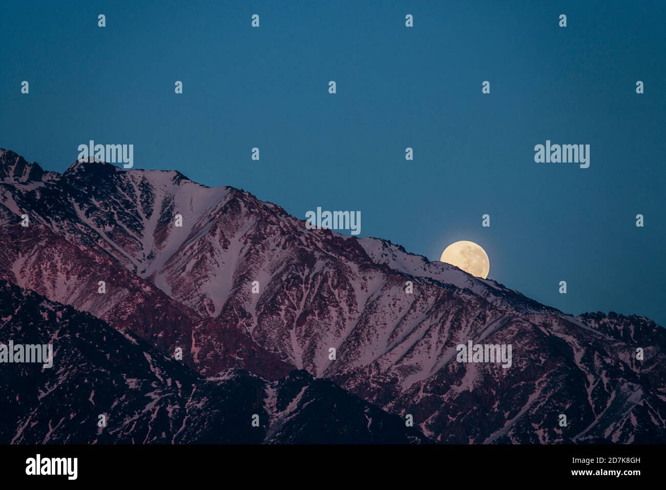 full moon hiding behind the andes mountain range in mendoza argentina ...