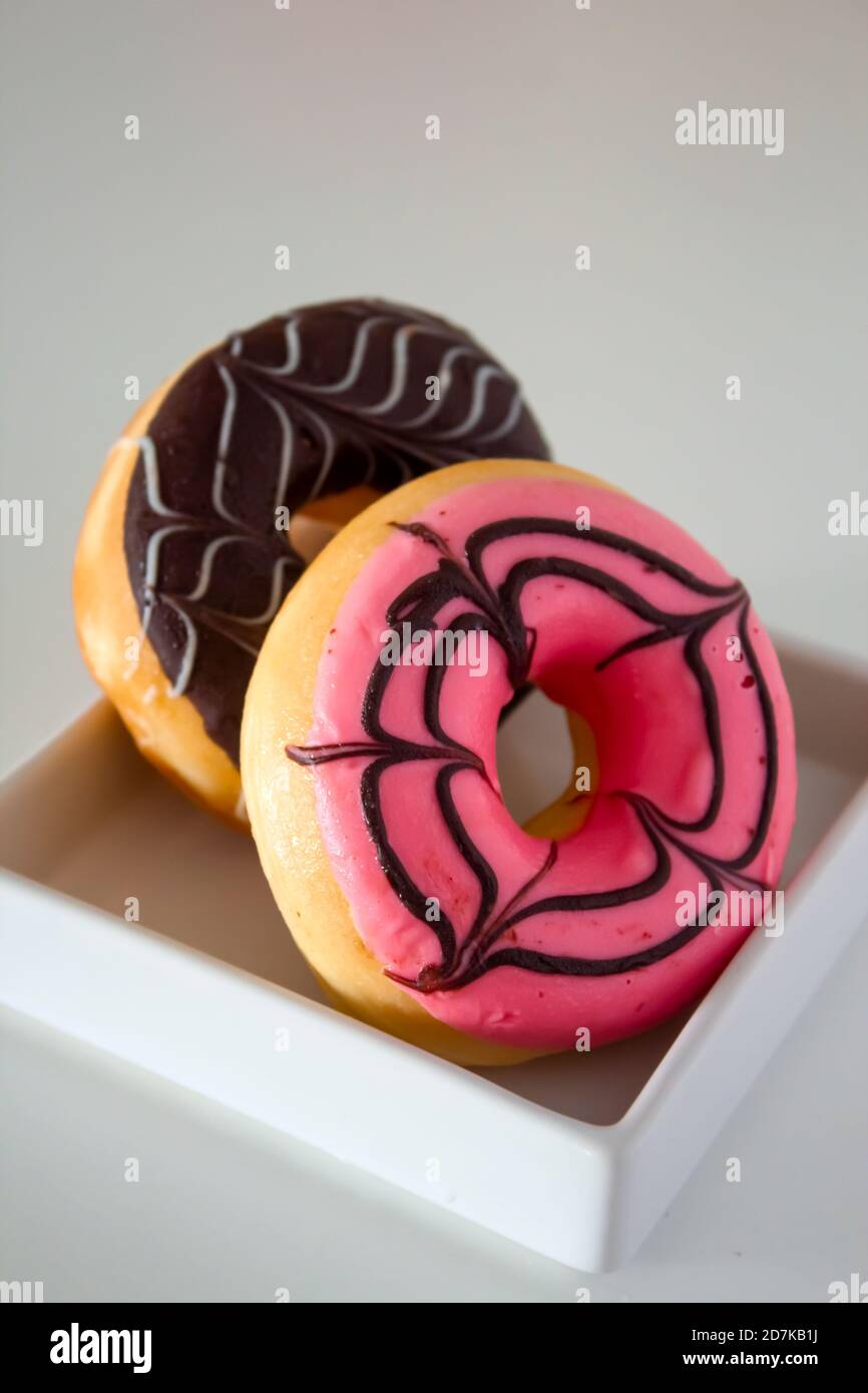 Two donuts in white box. Pink and chocolate donuts Stock Photo - Alamy