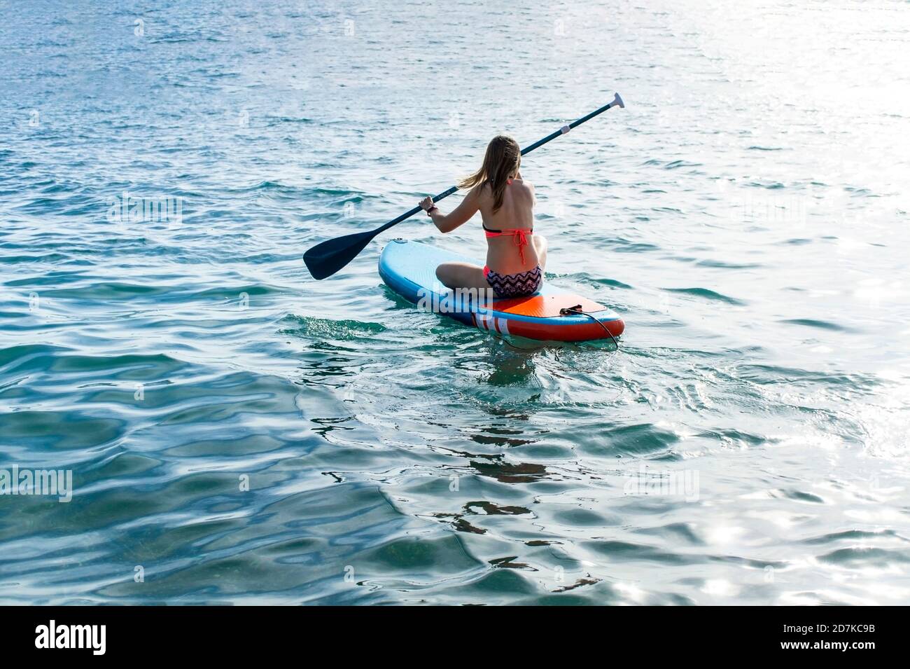 Woman sitting on paddle board hi-res stock photography and images - Alamy