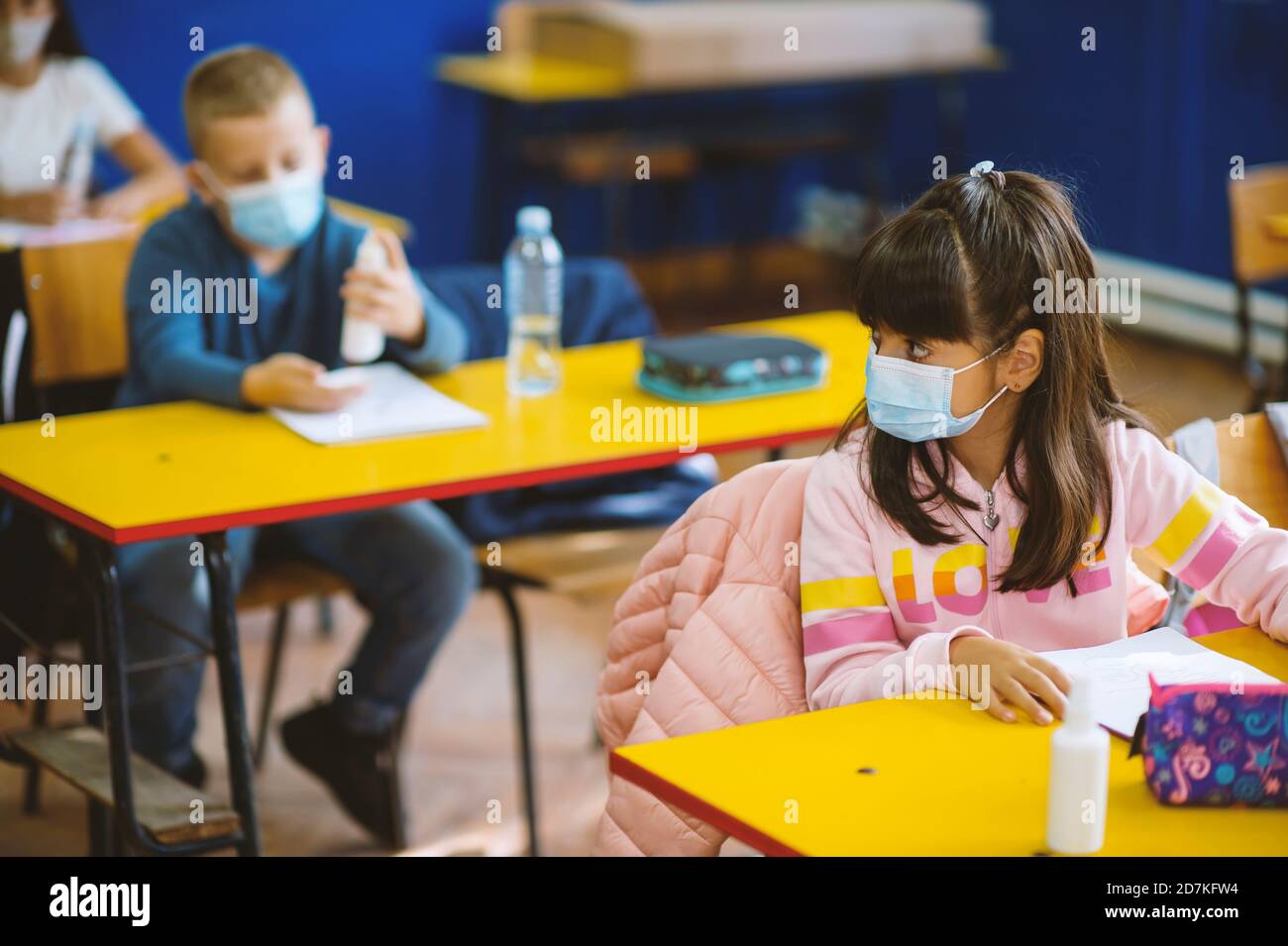 Elementary schoolchildren wearing a protective face masks in the ...