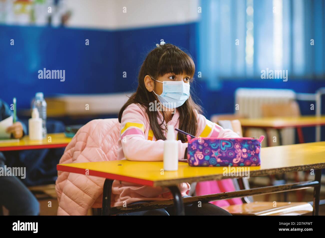 Elementary schoolchildren wearing a protective face masks in the ...