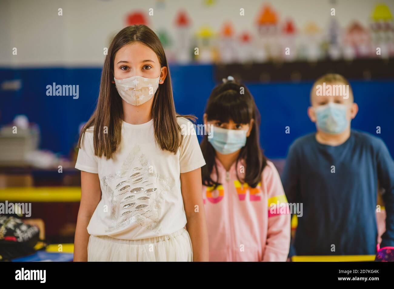 Elementary schoolchildren wearing a protective face masks in the ...