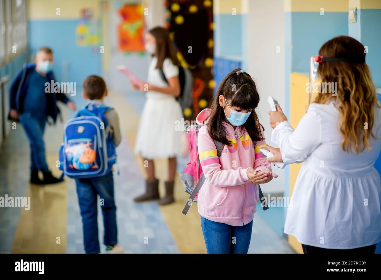 Teacher doing temperature check on school children Stock Photo - Alamy
