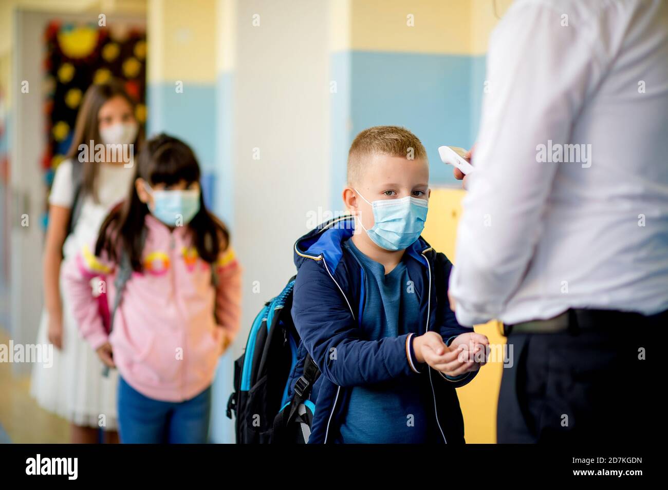 Teacher doing temperature check on school children Stock Photo - Alamy