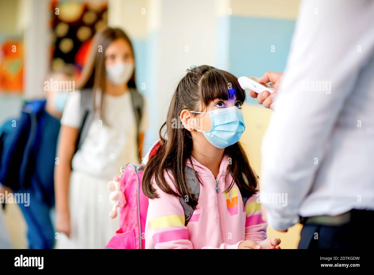 Teacher doing temperature check on school children Stock Photo - Alamy