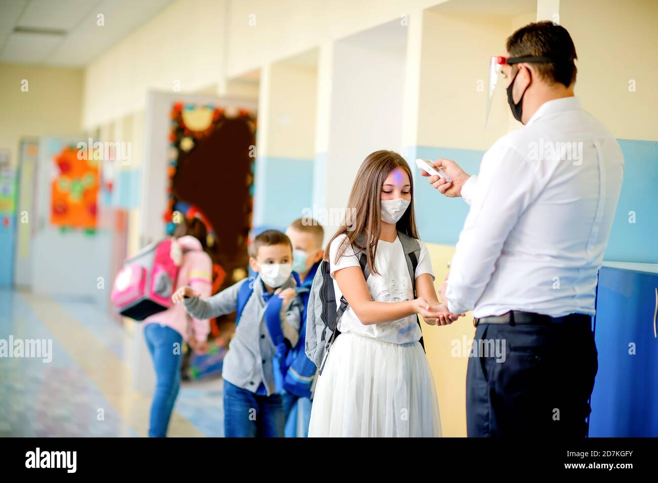 Teacher doing temperature check on school children Stock Photo - Alamy