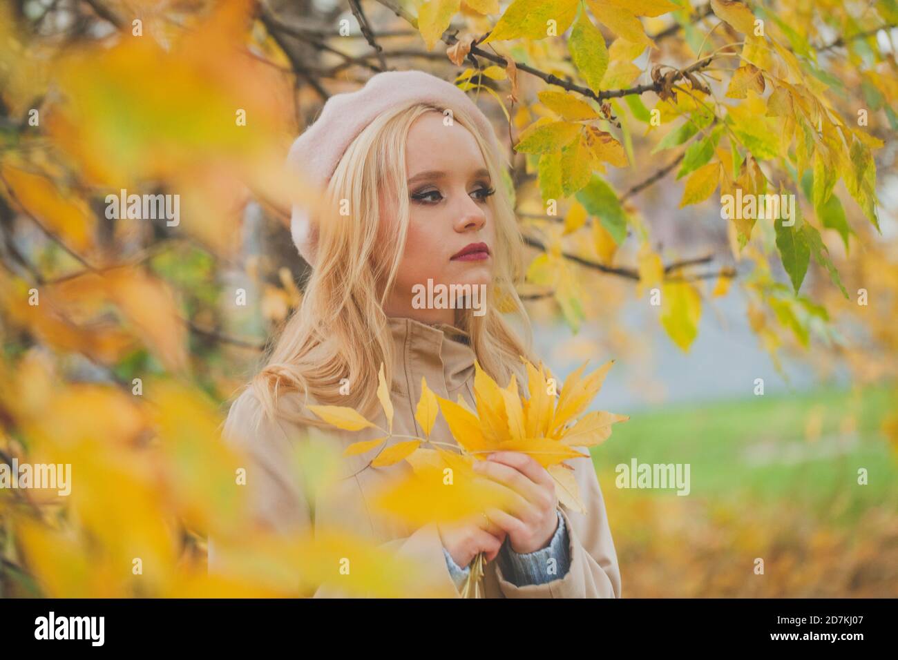 Beautiful blonde woman in fall park. Autumn woman with leaves in her ...