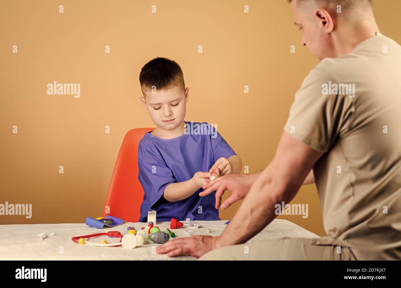 Kid little doctor sit table medical tools. Health care. Pediatrician ...