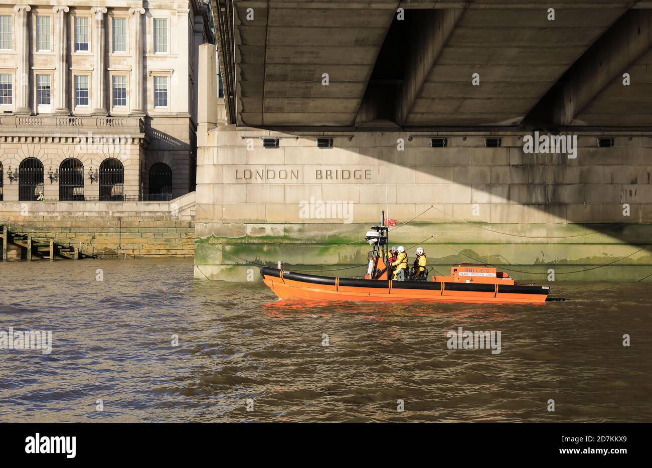 The RNLI rescue boat passing under London Bridge, on the River Thames ...