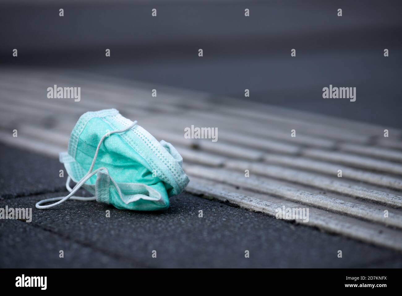 worn protective face mask lost on the pavement during corona pandemic ...