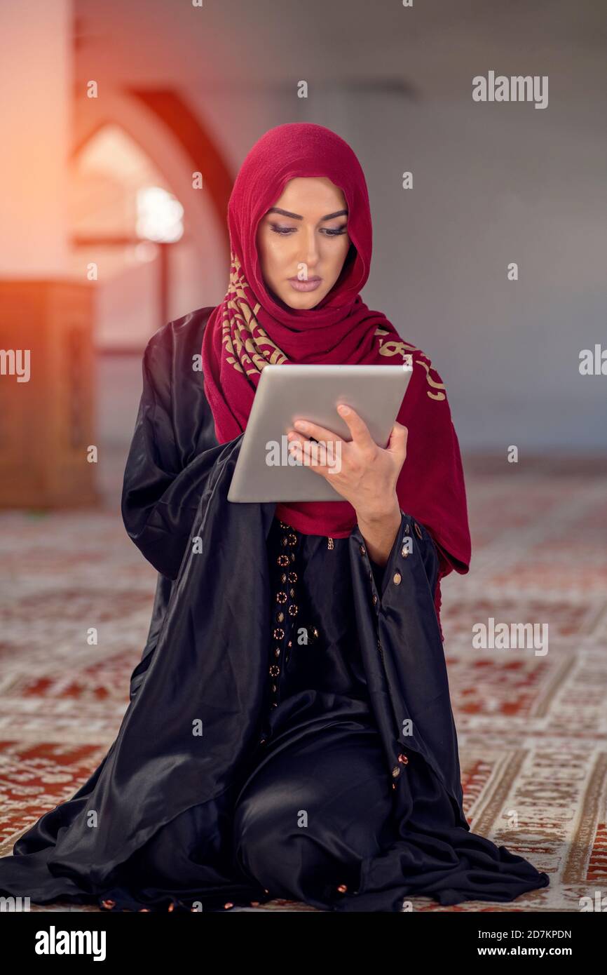 Young Muslim Woman Reading Quran In The Mosque And Sunlight Falling