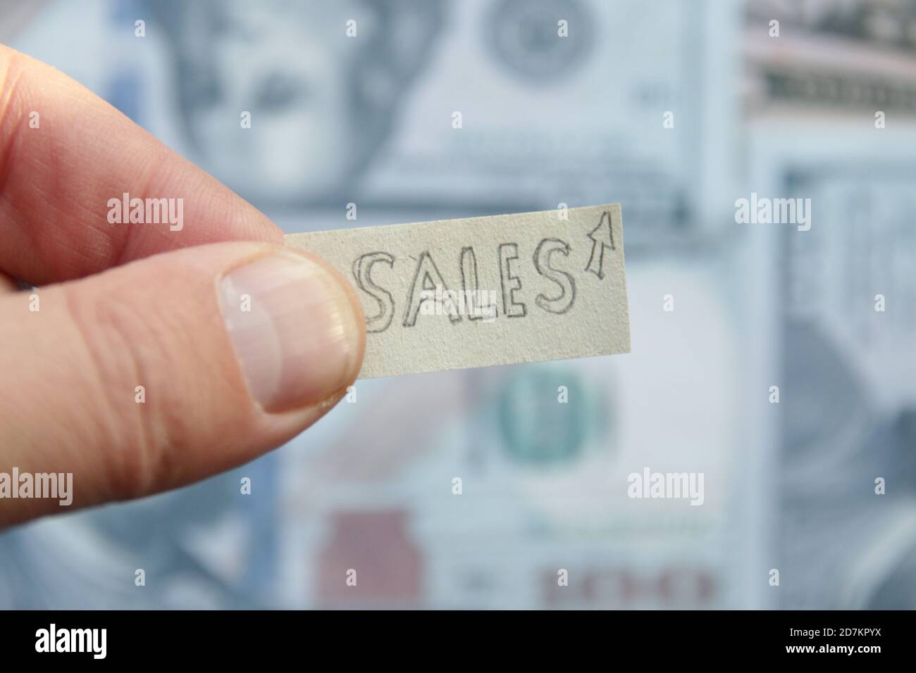 Sales growth concept. A hand holds a tag on the background of banknotes ...