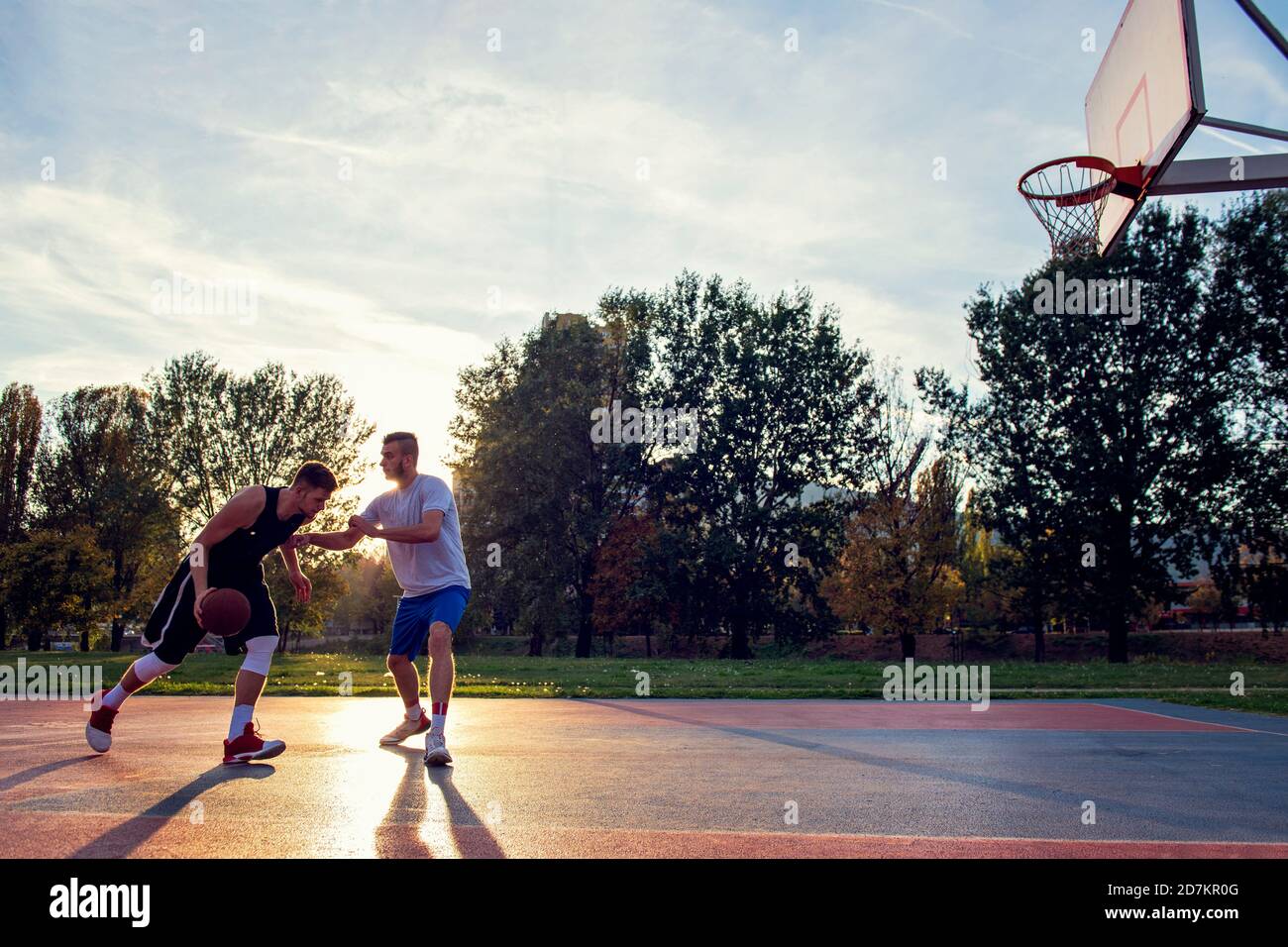 Two street basketball players playing hard on the court Stock Photo - Alamy