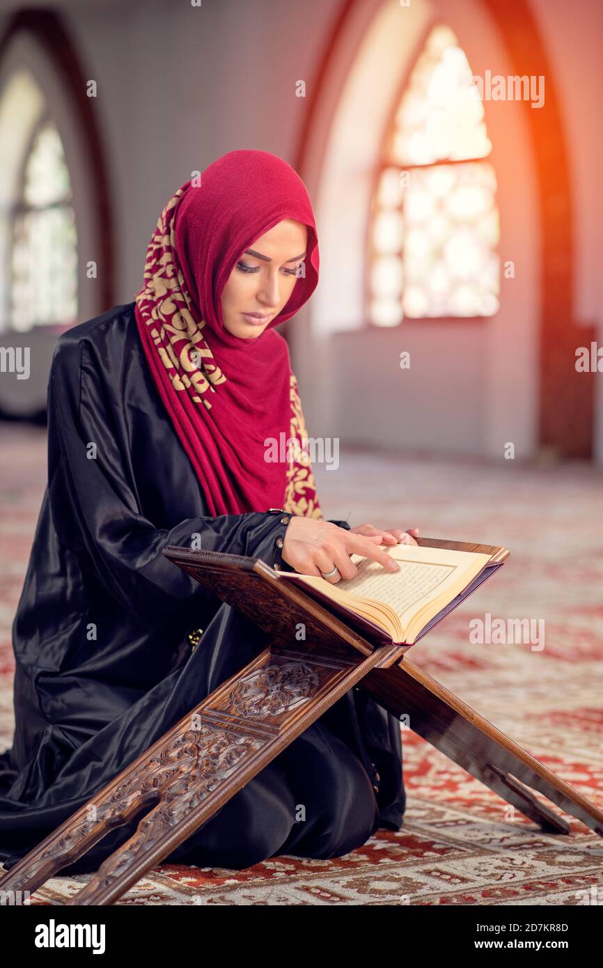 Young Muslim Woman Reading Quran In The Mosque And Sunlight Falling