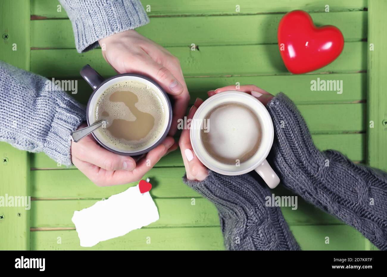 Couple drinking hot coffee at wooden table on a date Stock Photo - Alamy