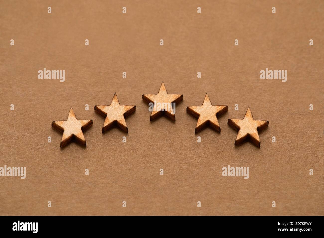 Five wooden stars on cardboard background Stock Photo - Alamy