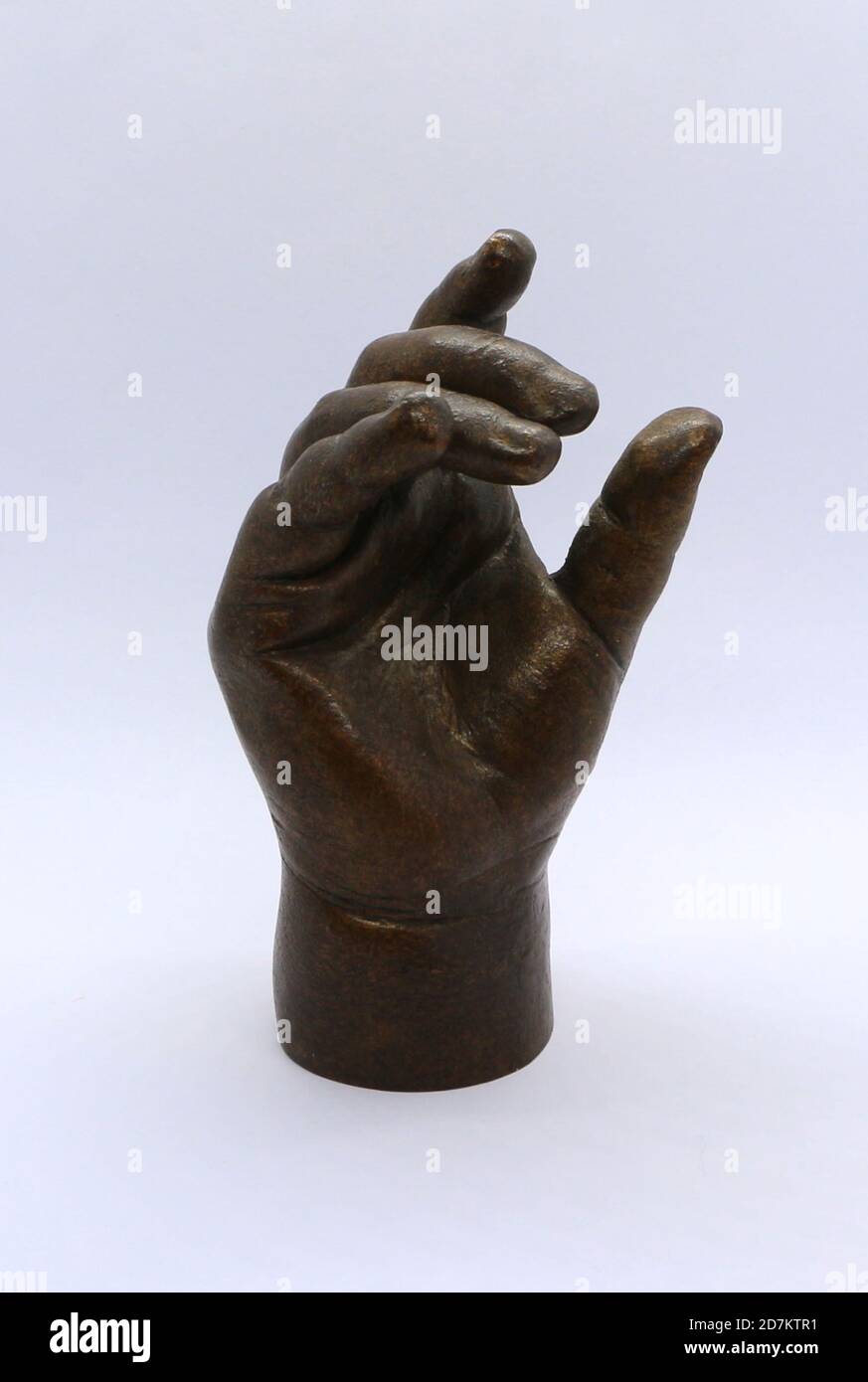 Photo of a Child's hand sculpture cast in bronze and strongly lit ...