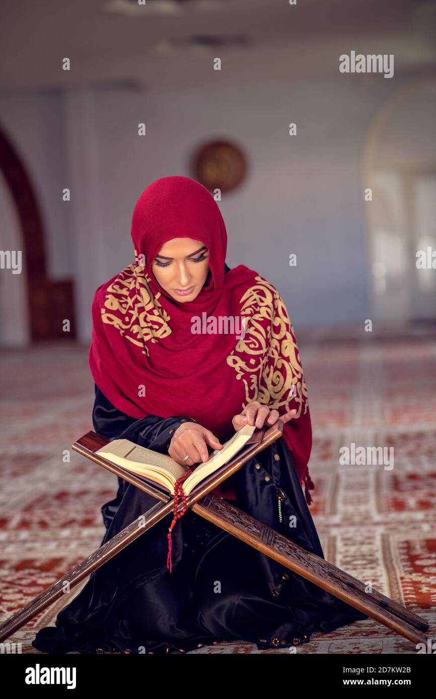 Young muslim woman reading Quran in the mosque and sunlight falling ...
