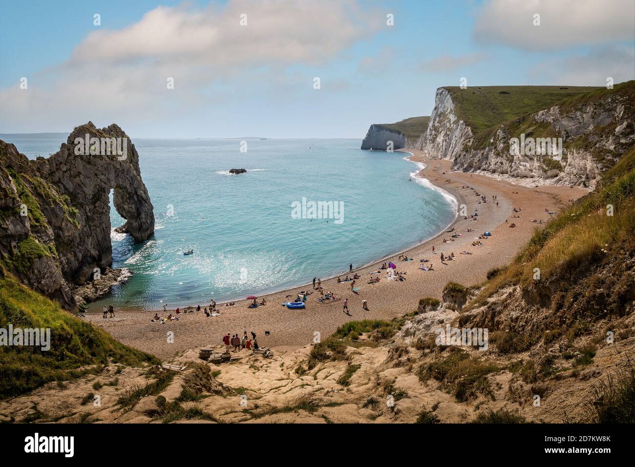 Durdle Door Bay and natural arch with swimers on the beach in Durdle ...