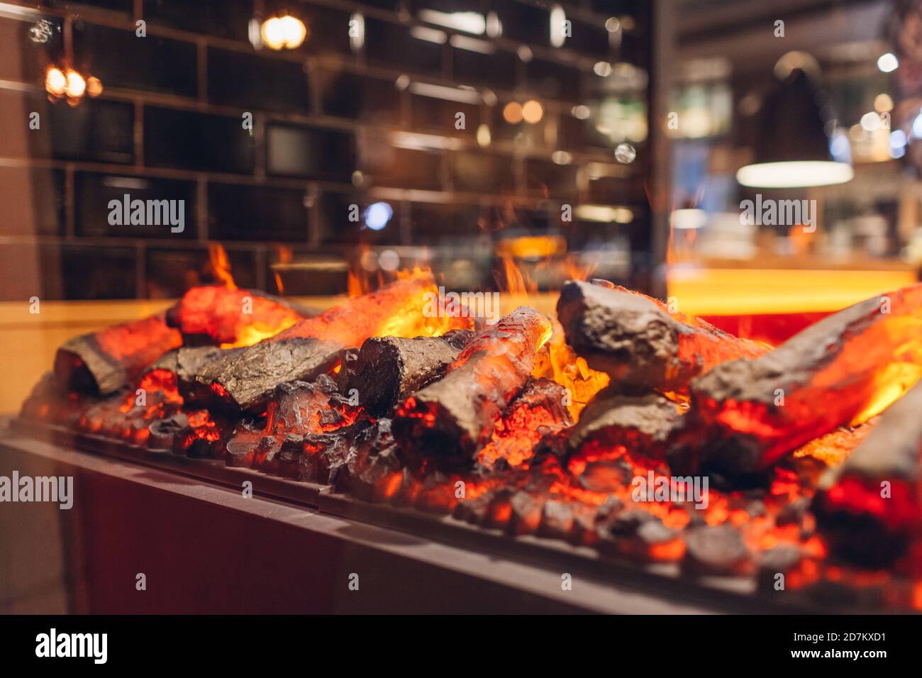 Electric log fireplace. Restaurant showcase decorated with artificial ...