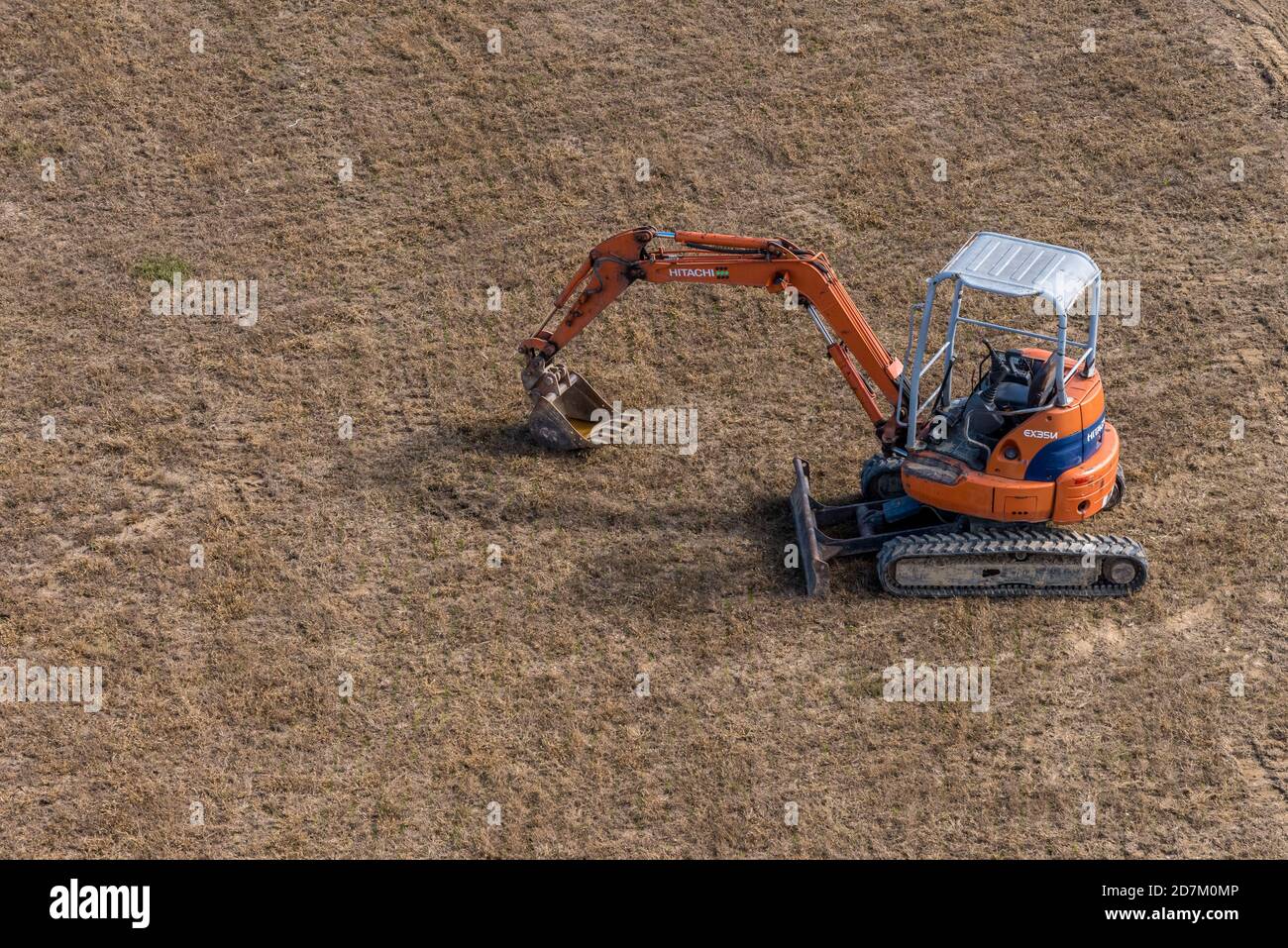 Overhead, aerial view of small back hoe in field Stock Photo - Alamy
