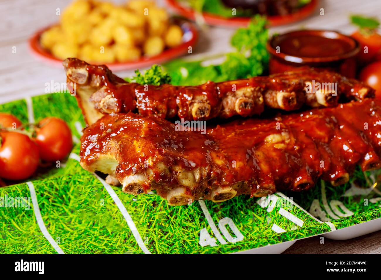 Baked juicy barbecue pork ribs with tomato, sauce and potato on ...