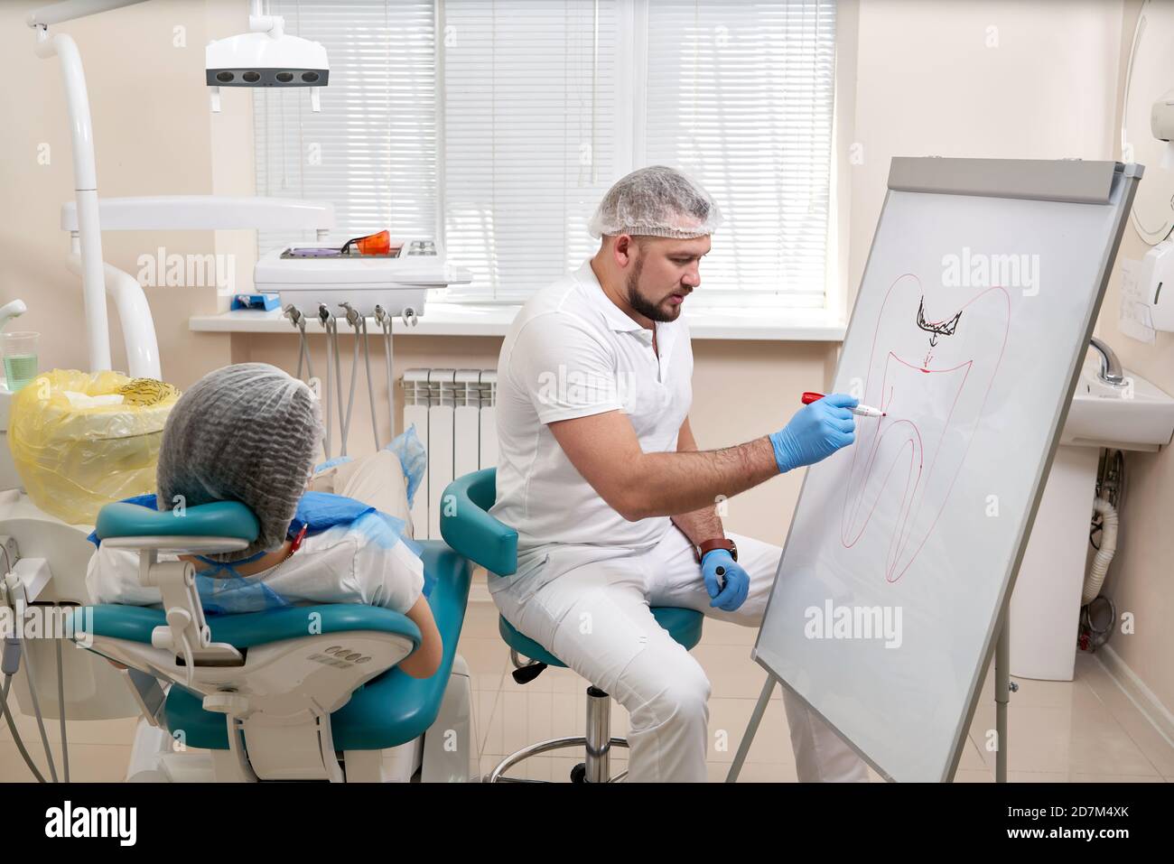 Dentist drawing picture of tooth on white board in dentist office Stock ...