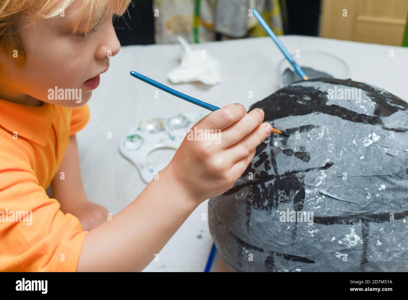 Child doing art and craft the boy is painting his project at home Stock ...