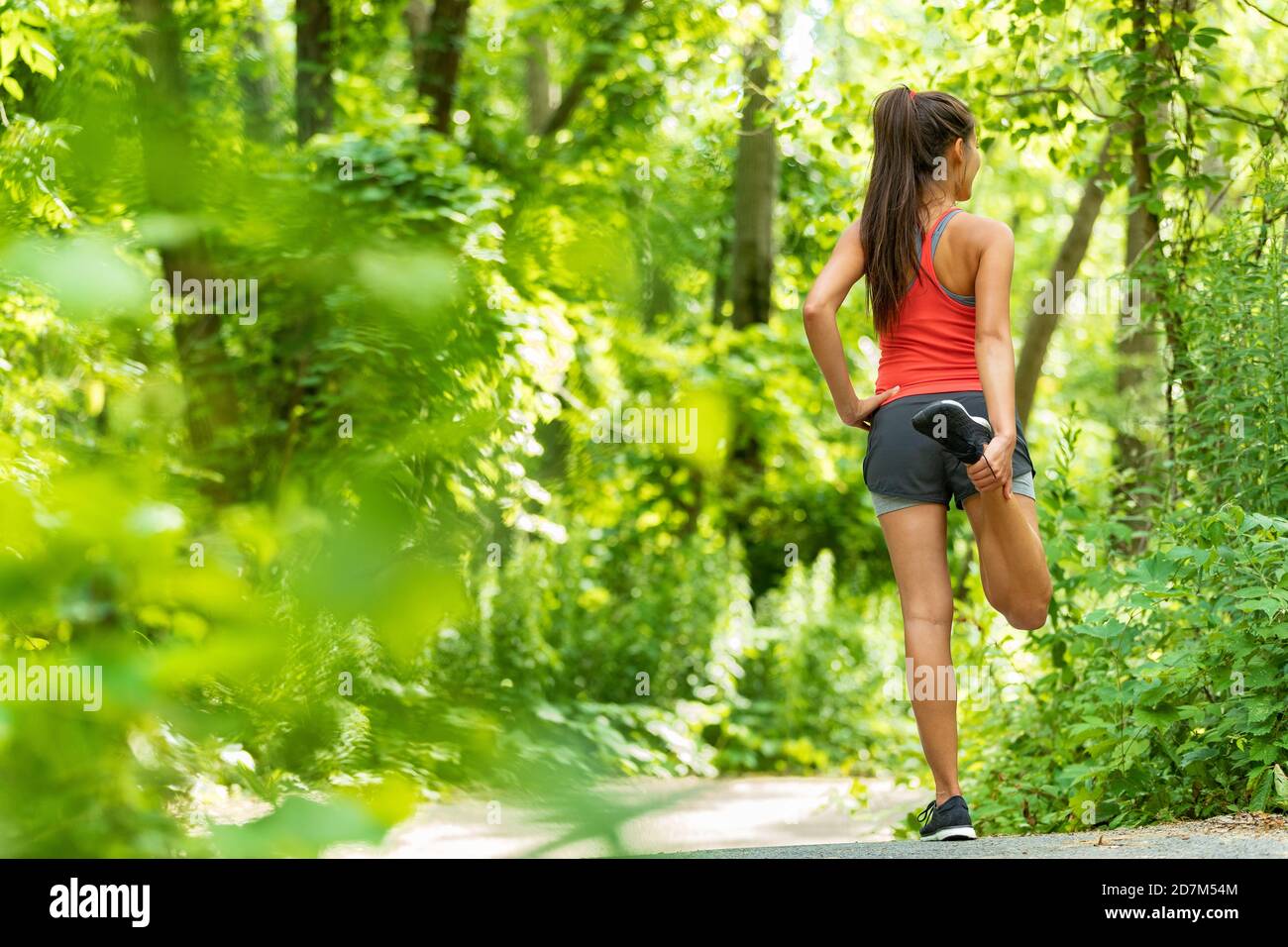 Fit stretch woman stretching quad leg muscle standing getting ready to ...