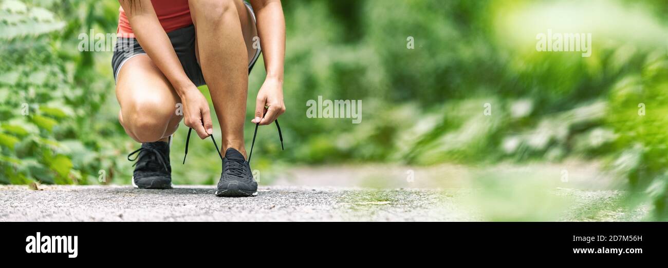 Road to Fitness healthy girl getting ready to run tying shoe laces outside lacing running shoes ...