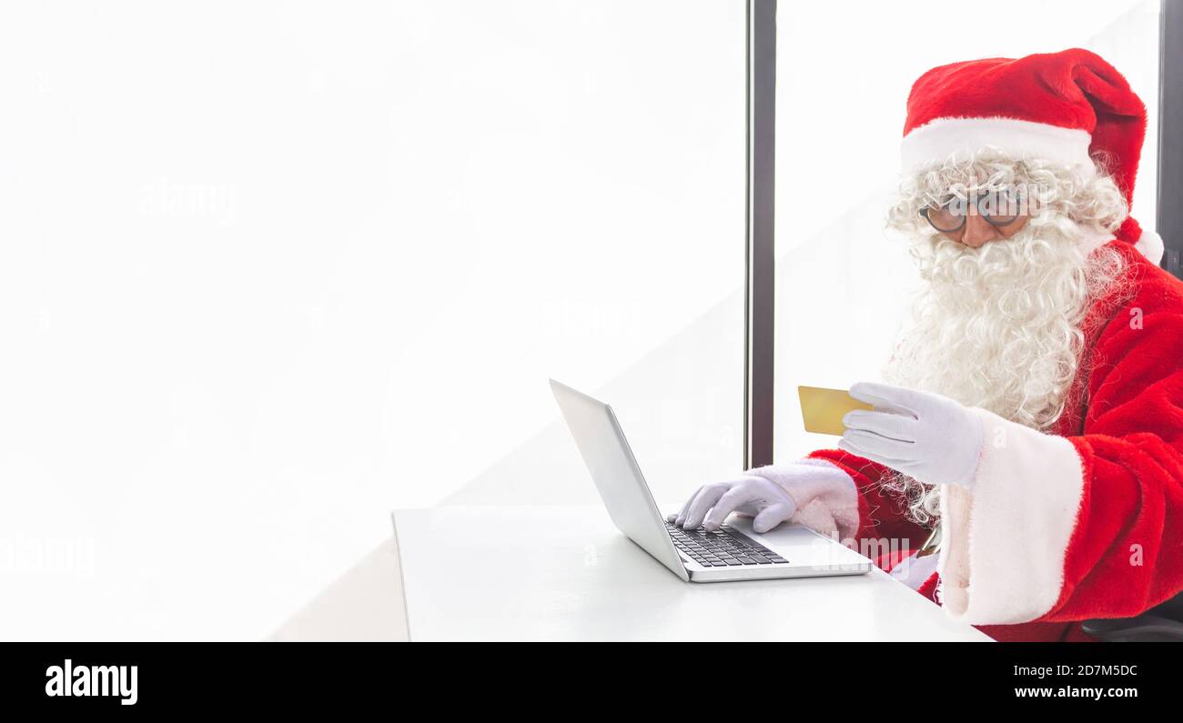 Santa Claus working on a laptop in a minimalist white office at ...