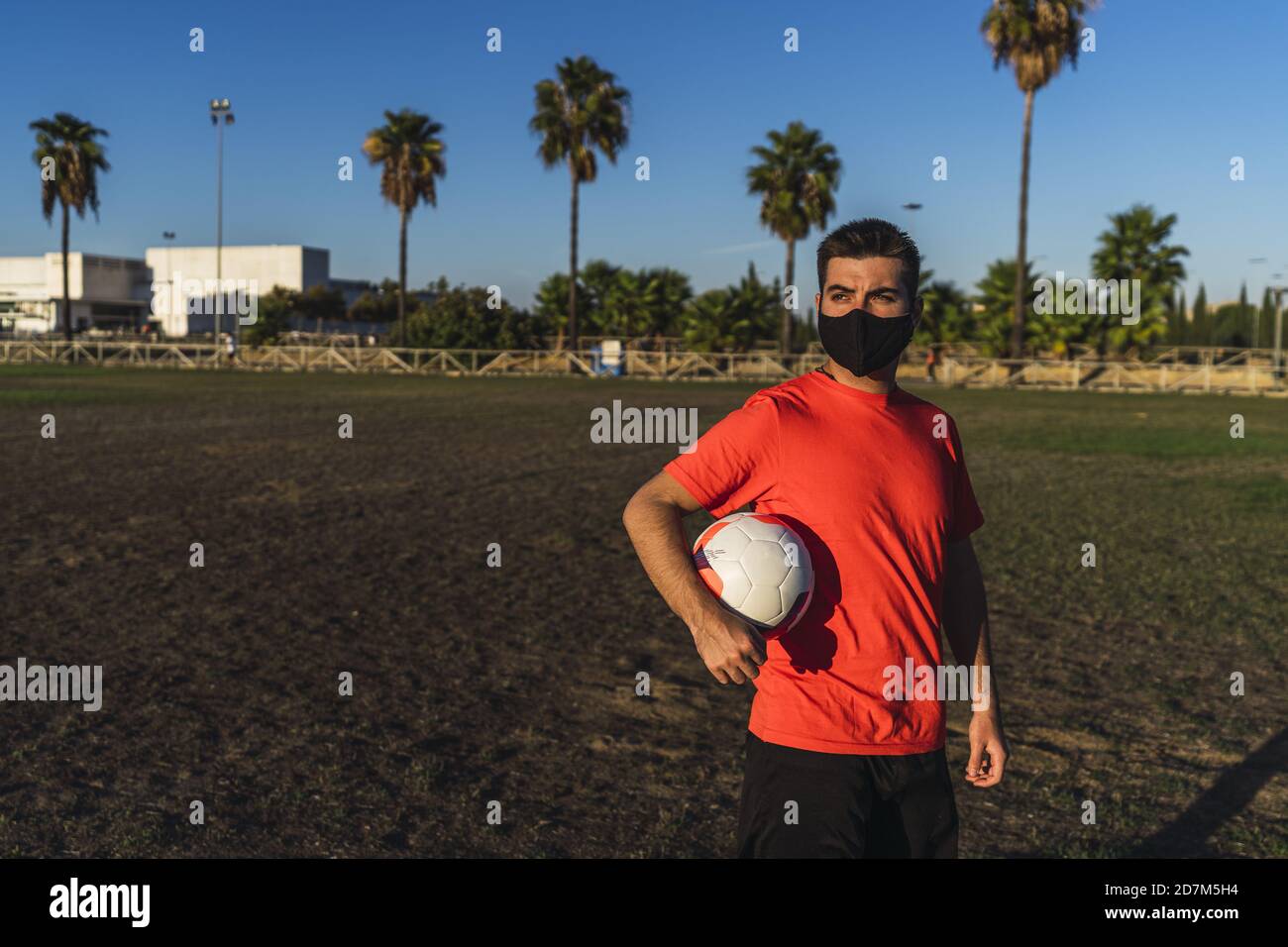 Footballer in a black mask posing with a ball Stock Photo - Alamy