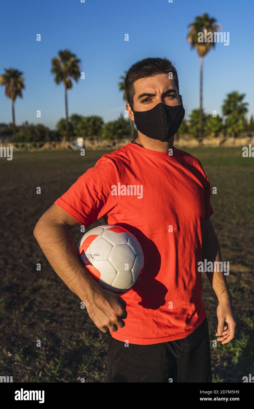 Footballer in a black mask posing with a ball Stock Photo - Alamy