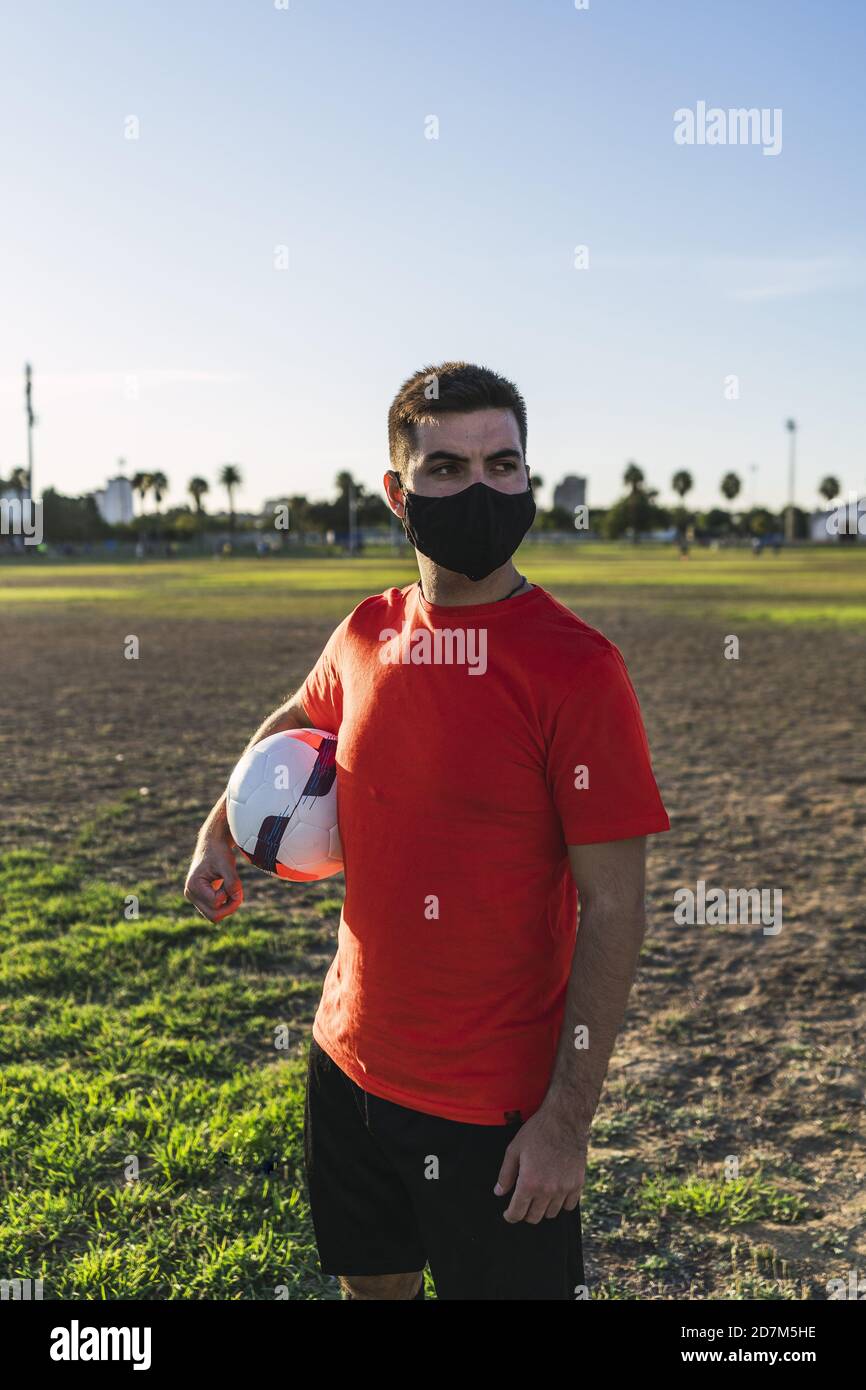 Footballer in a black mask posing with a ball Stock Photo - Alamy